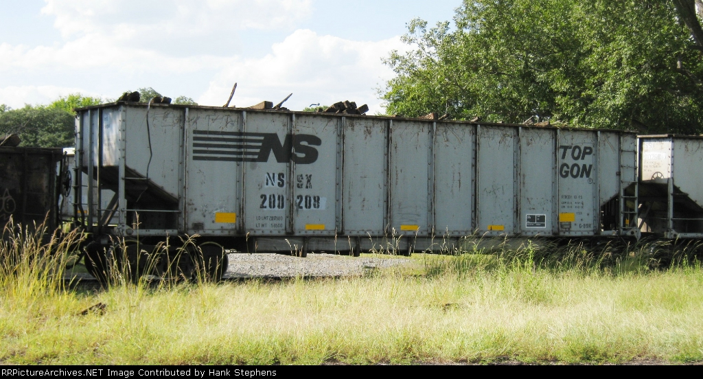 NSSX 200208 sits with several other Top Gons loaded with old cross ties, likely for burning by a ...